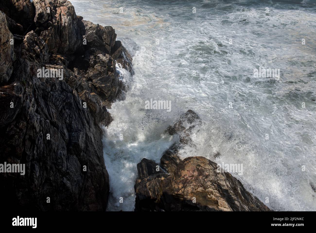 The huge waves crashing into ston island against the blue sky and ...