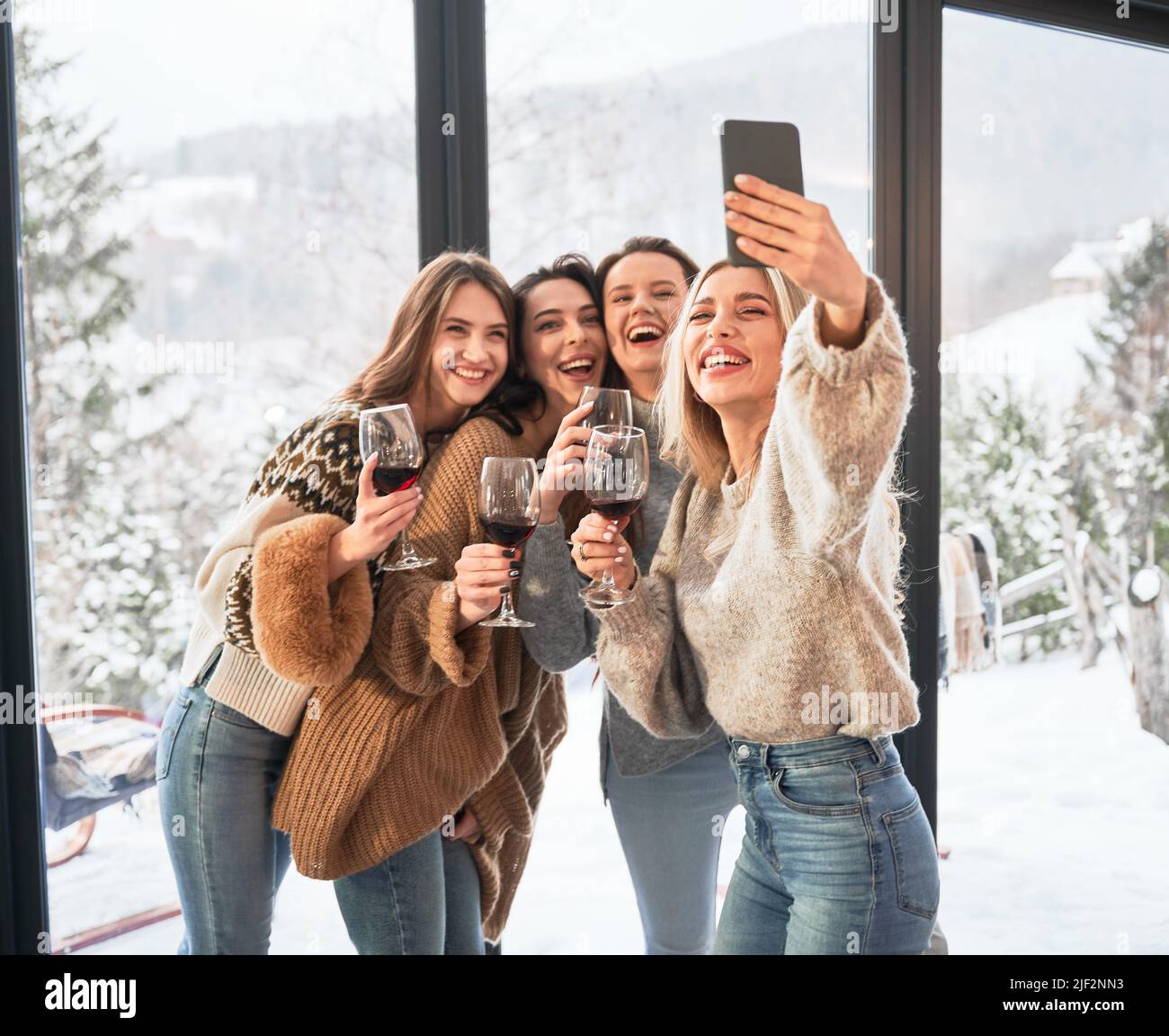 Young women enjoying winter weekends inside contemporary barn house ...