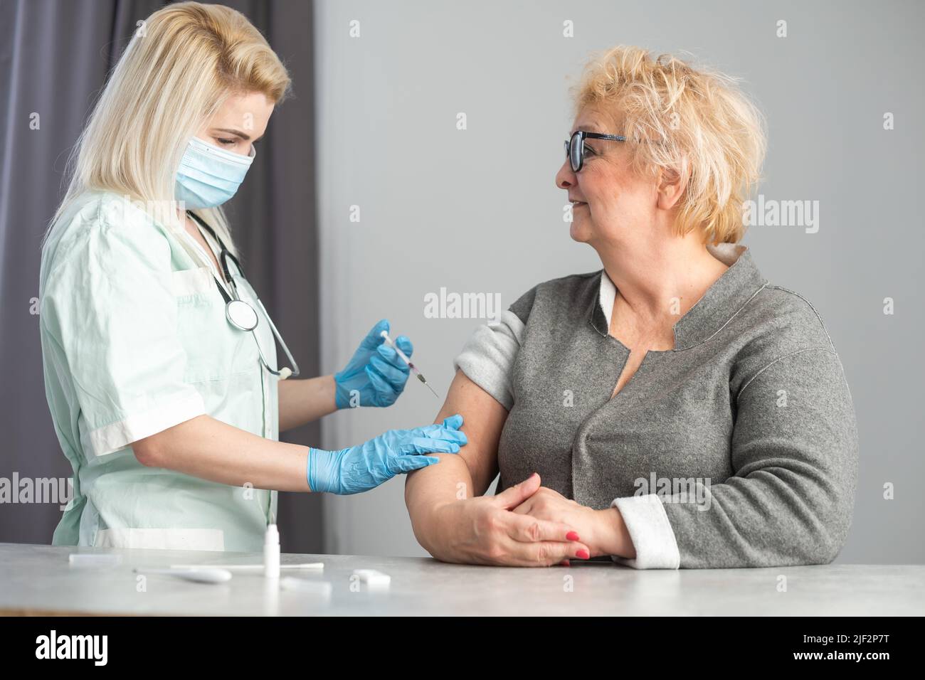 Closeup nurse doing vaccine injection to senior woman Stock Photo - Alamy