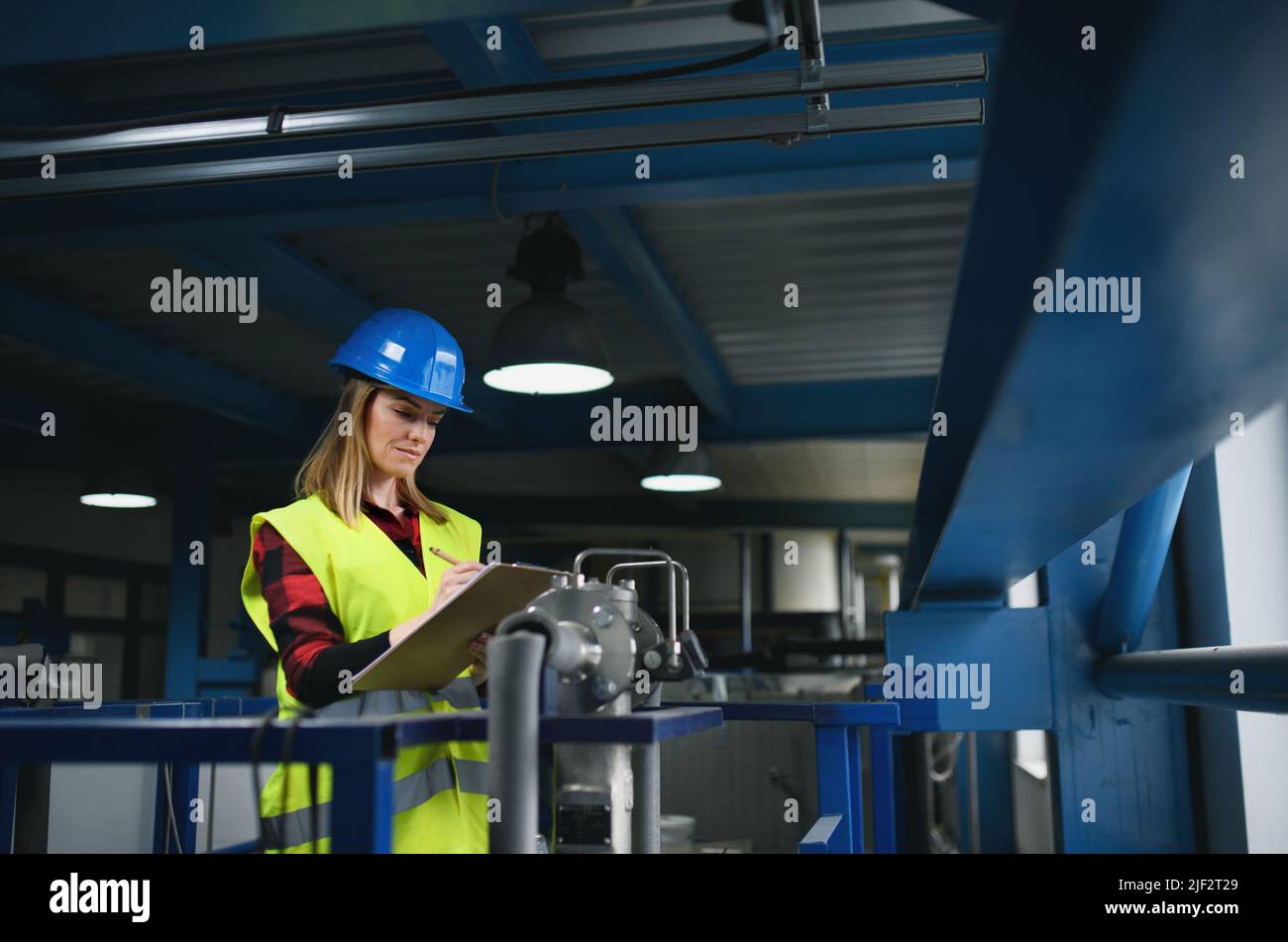 Portrait of female engineer working in industrial factory, doing ...