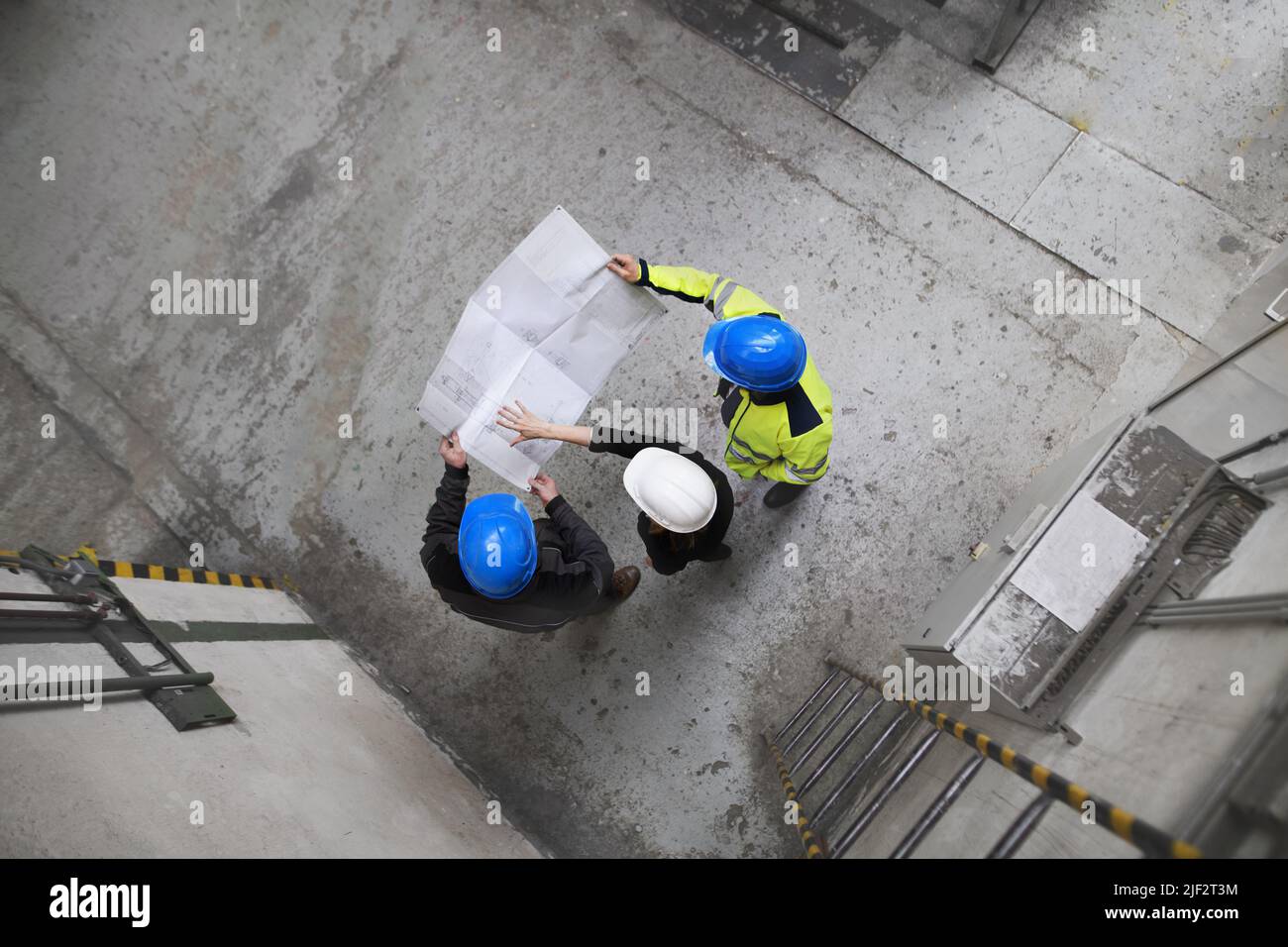 Top view of engineer and industrial worker in uniform shaking hands in ...