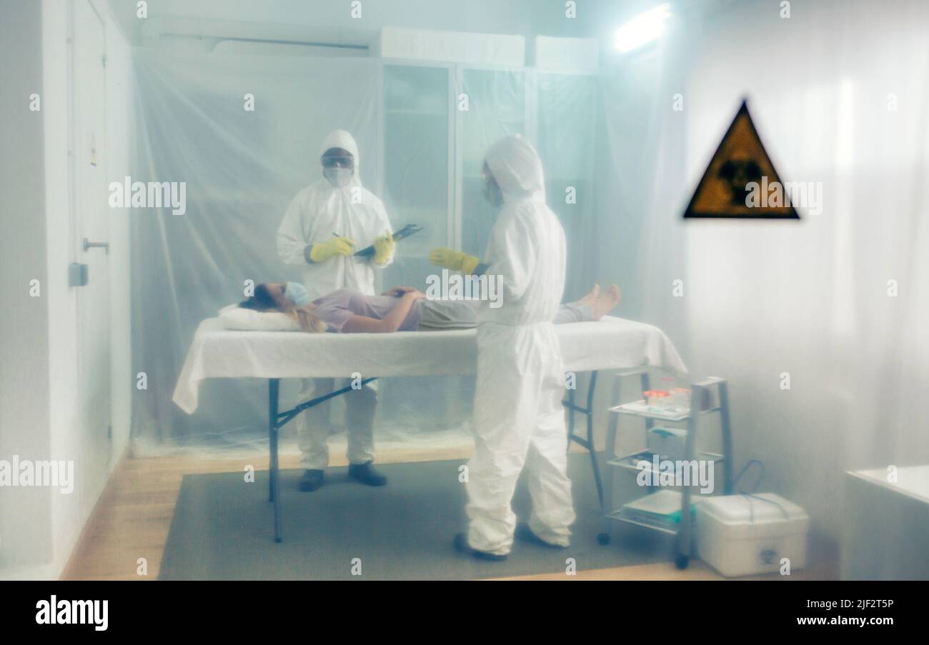 Doctors in bacteriological protection doing medical check to patient ...