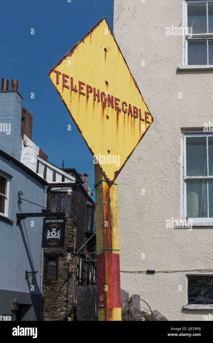 Old yellow and red sign making position of underwater telephone cable ...