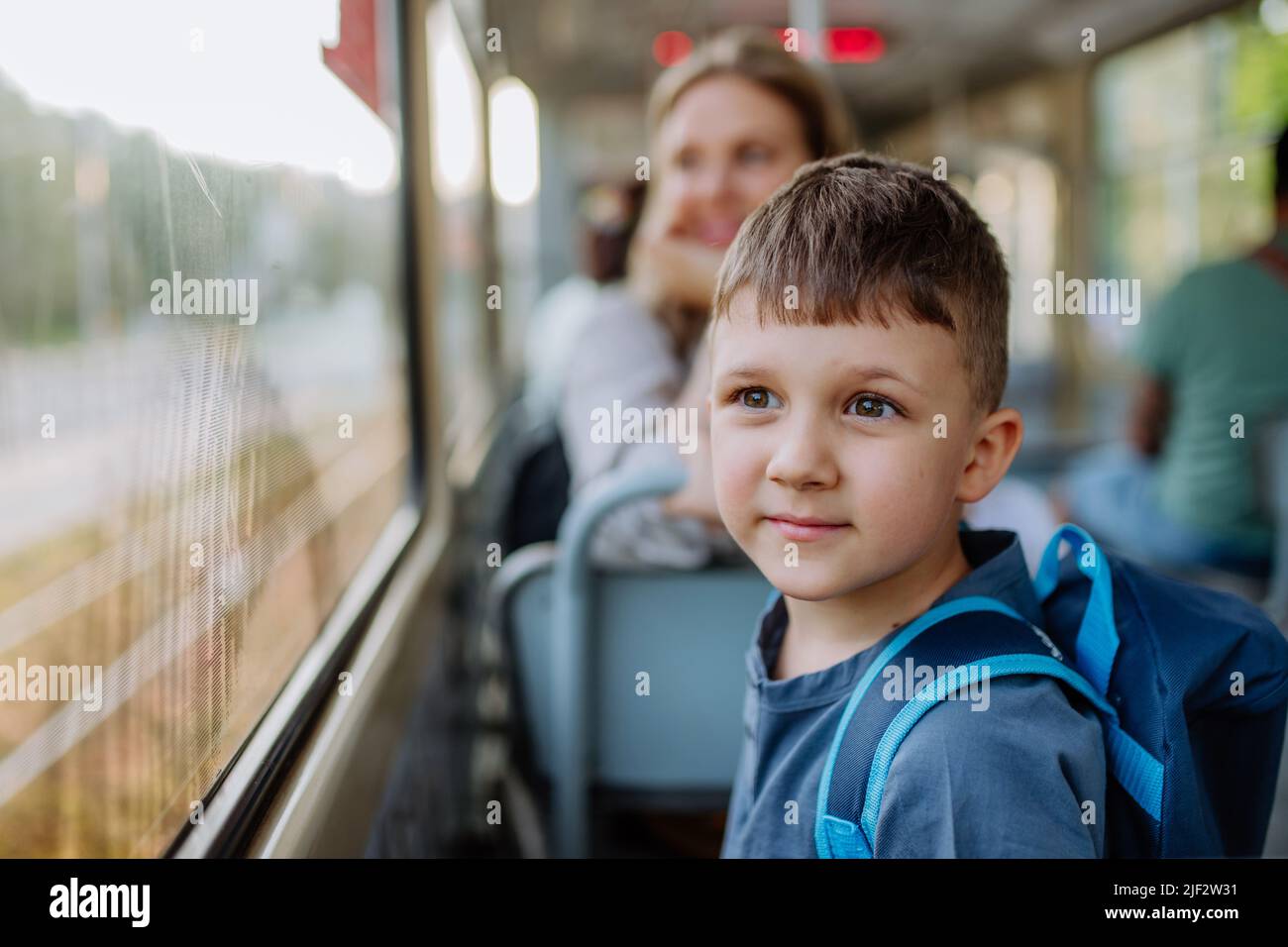 Close-up of little boy travelling to school by bus in the morning ...