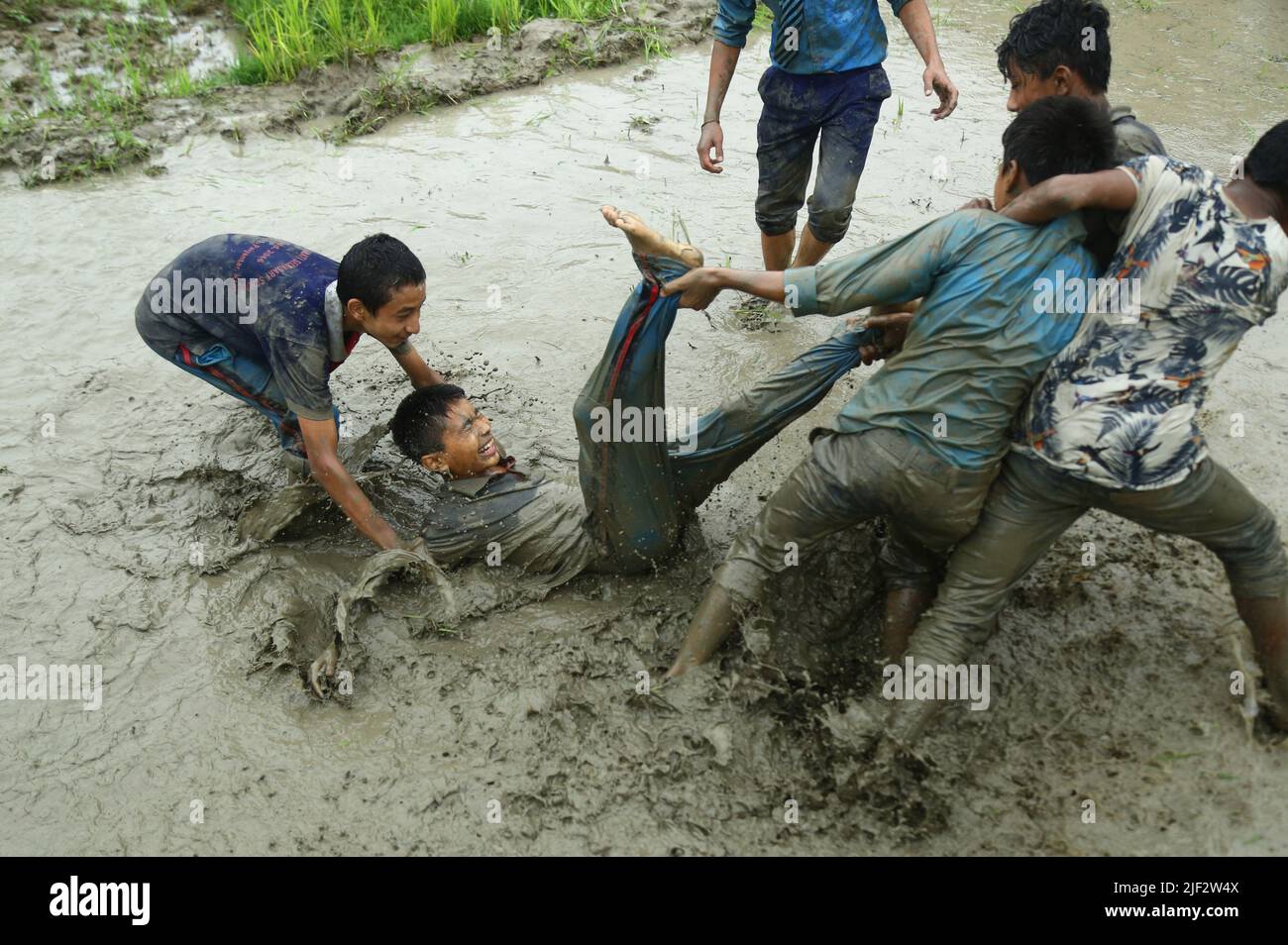 Kathmandu, Nepal. 29th June, 2022. Students play in mud as they plant ...