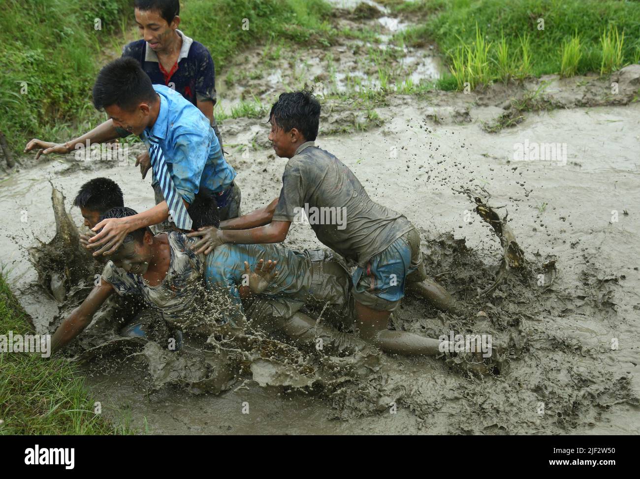 Kathmandu, Nepal. 29th June, 2022. Students play in mud as they plant ...