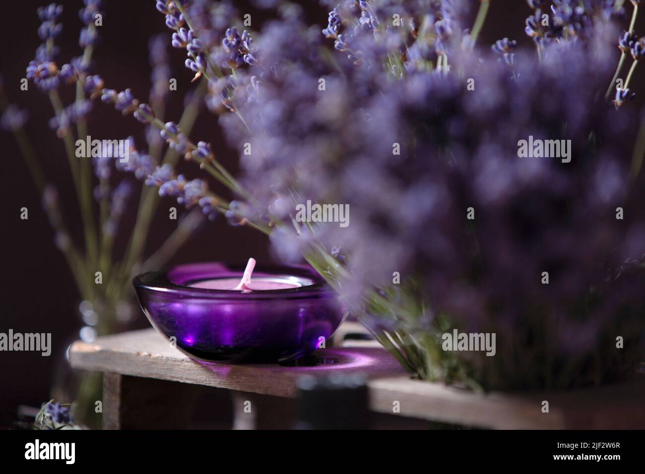 Purple tea candle and lavender flowers still-life on wooden background ...