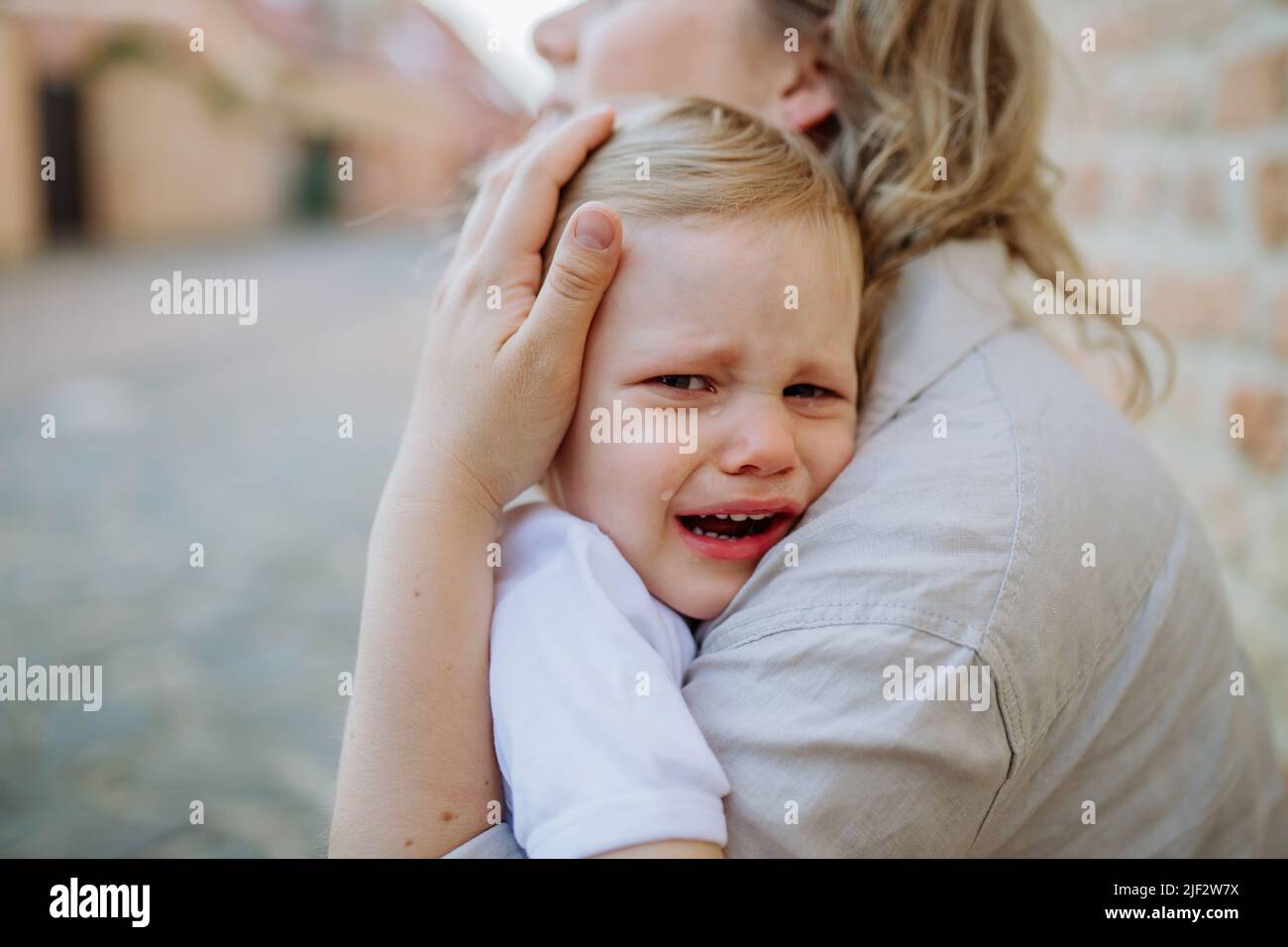 Unrecognizable mother consling her little daughter crying, holding her ...