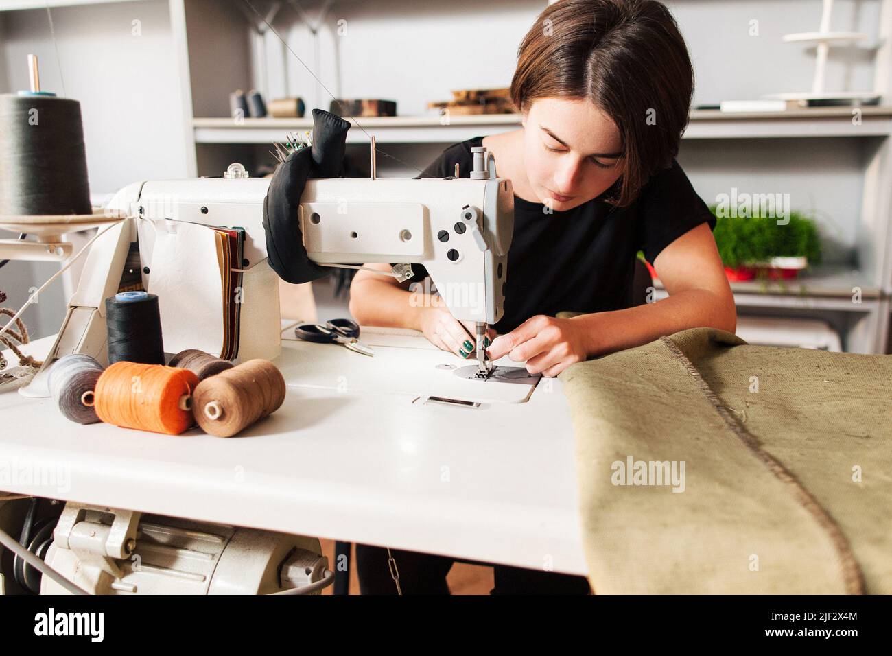 seamstress put thread in needle Stock Photo - Alamy