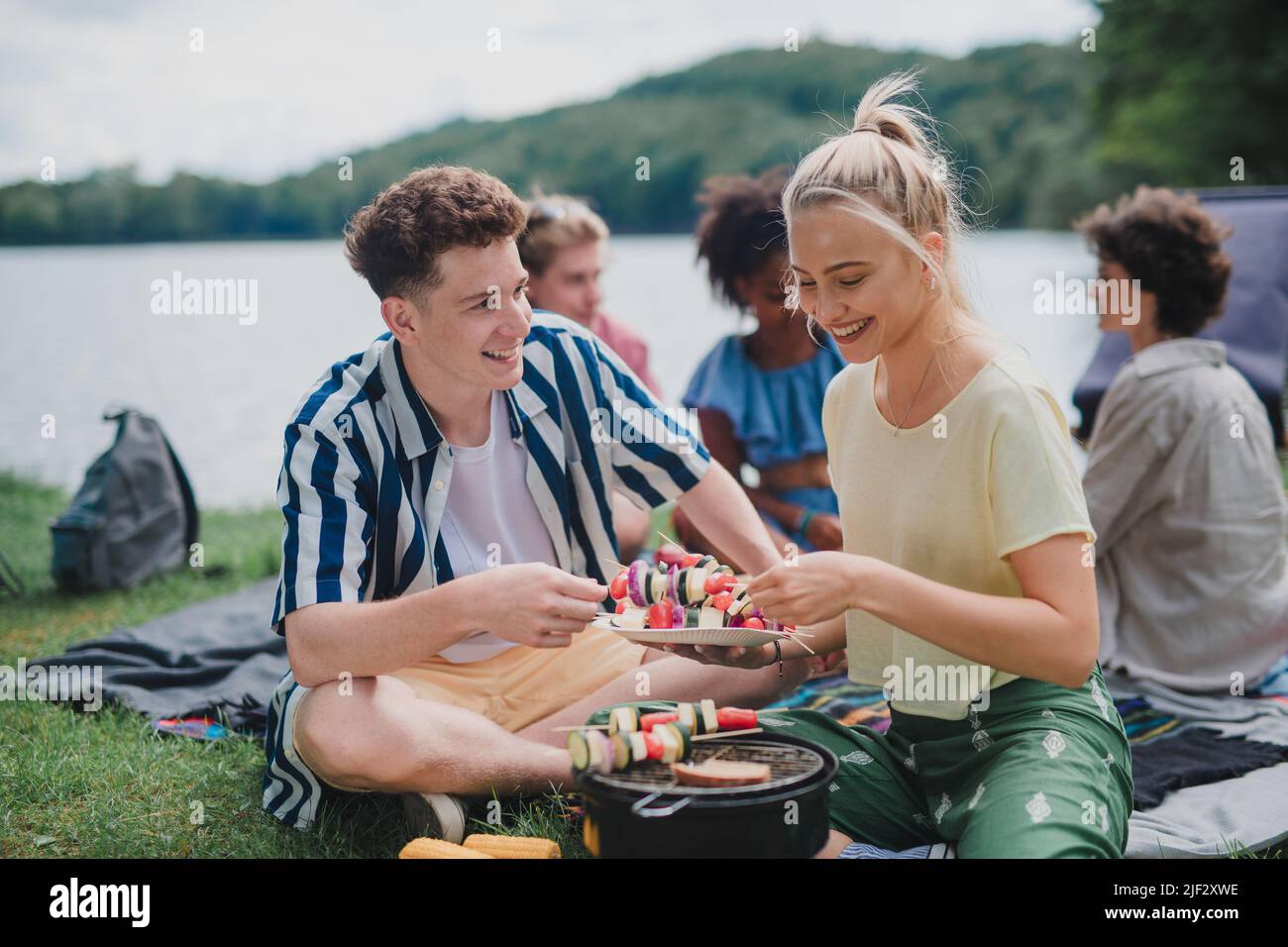 Group of multiracial young friends camping in campsite near lake and ...