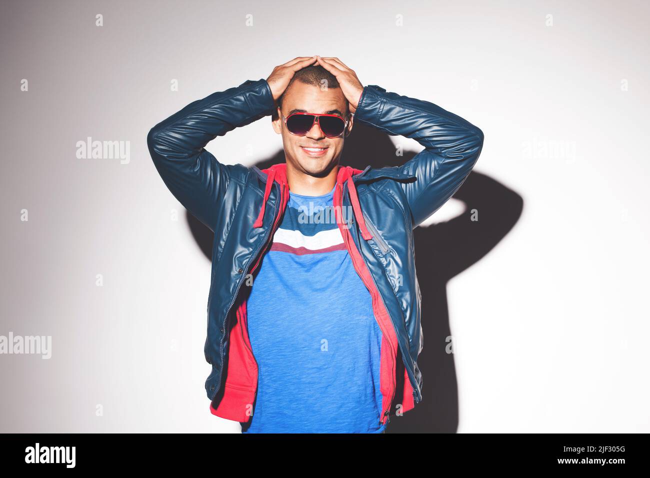 Man fashion model posing against a studio background Stock Photo - Alamy