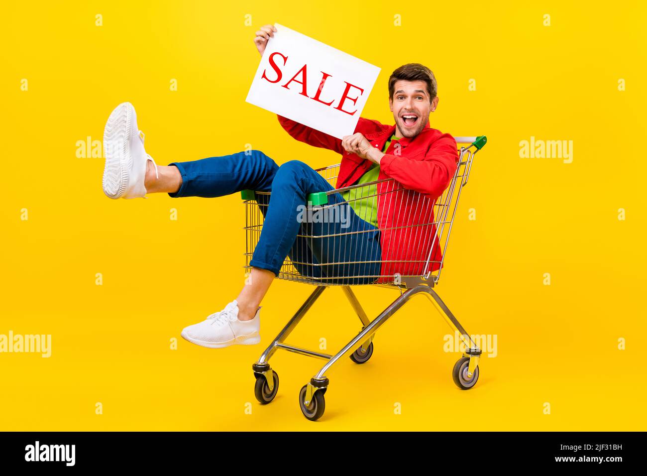 Full length body size view of attractive cheerful guy riding cart ...