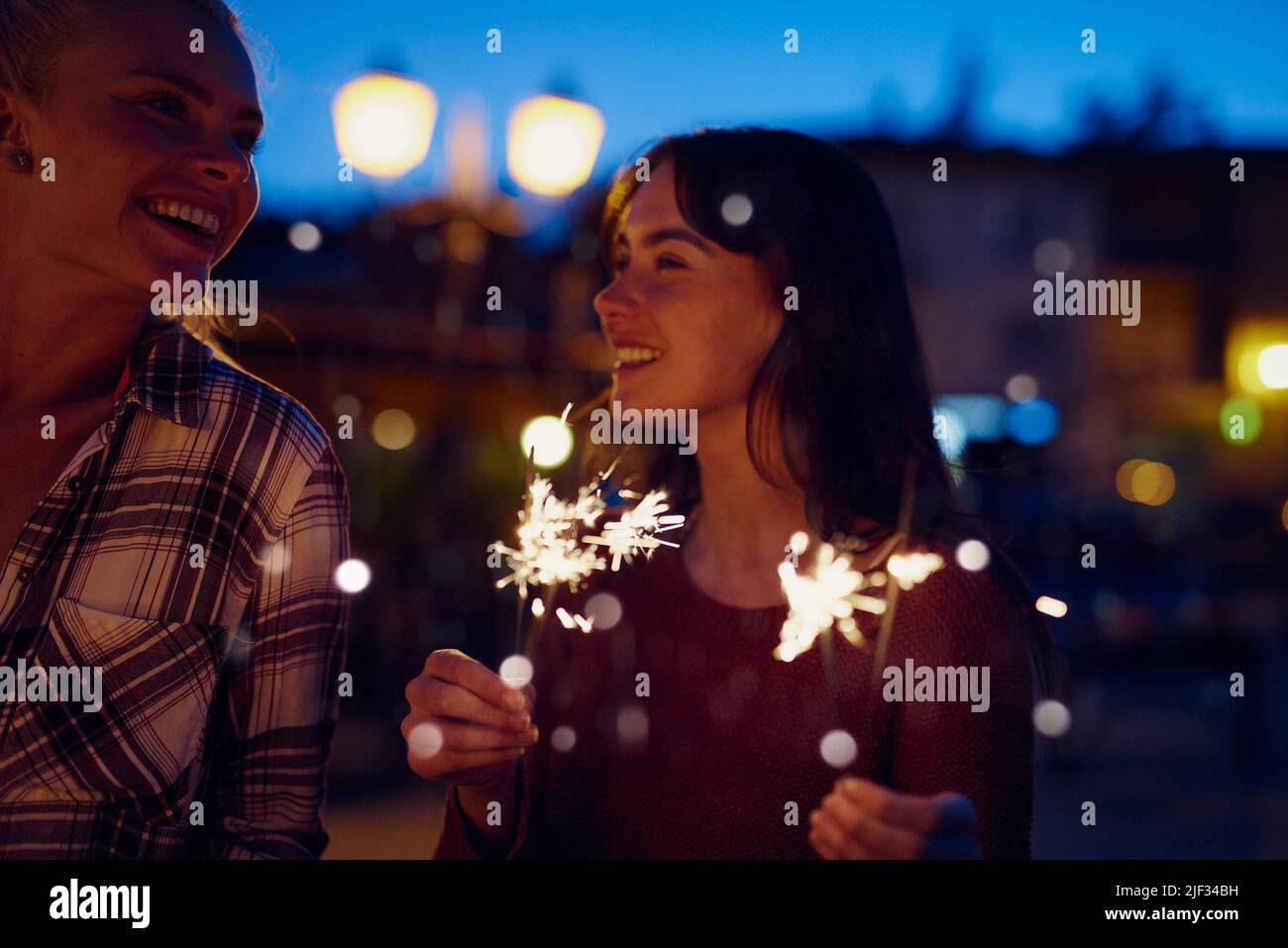 Young woman smiling at her friend and celebrating playing with ...