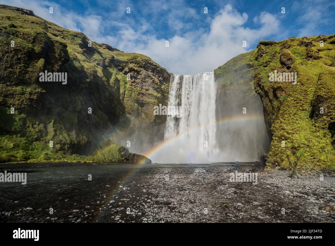 a heavenly view of a Skogafoss waterfall with a small rainbow ...