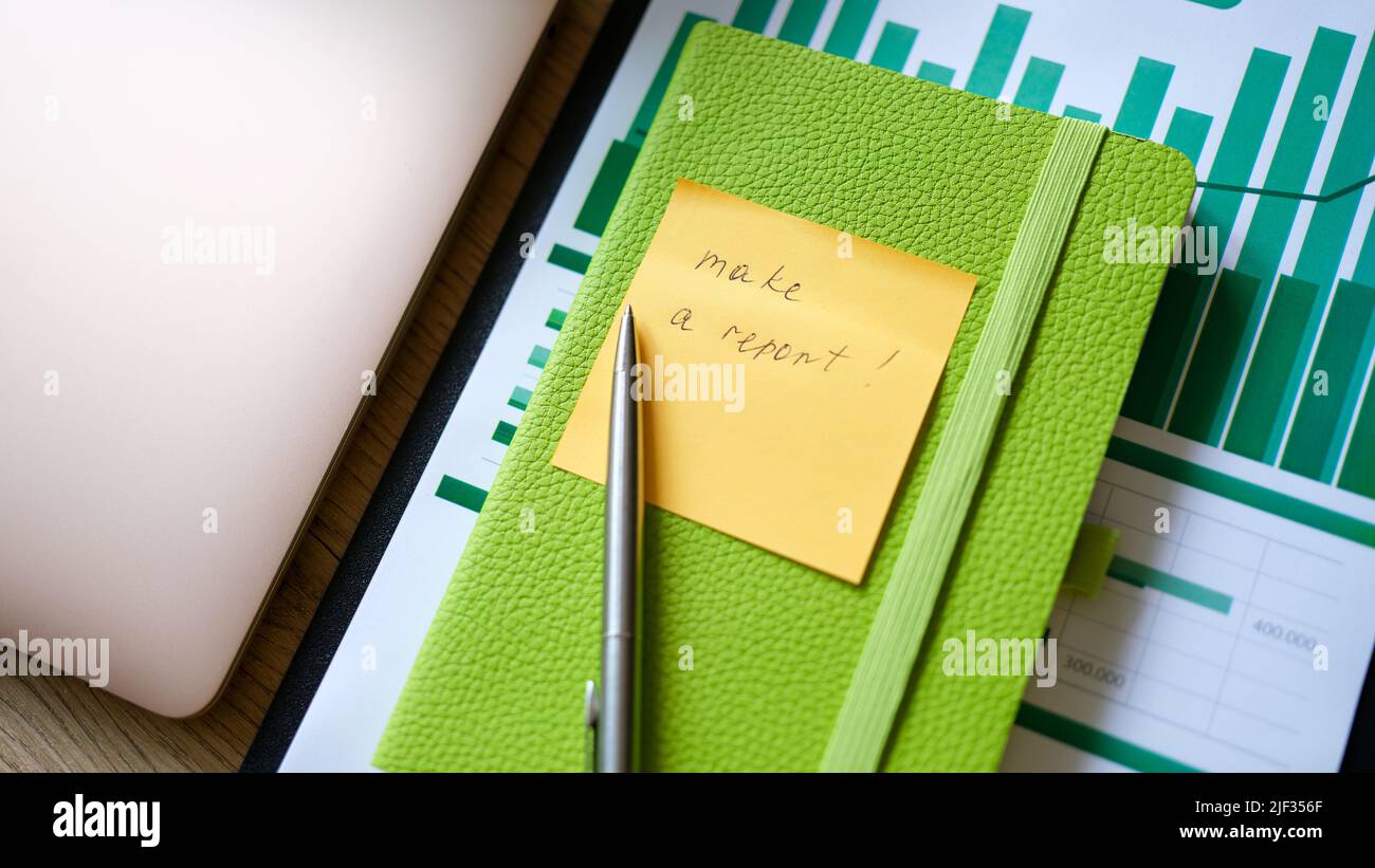 Financial report and notepad with note reminder pen Stock Photo - Alamy