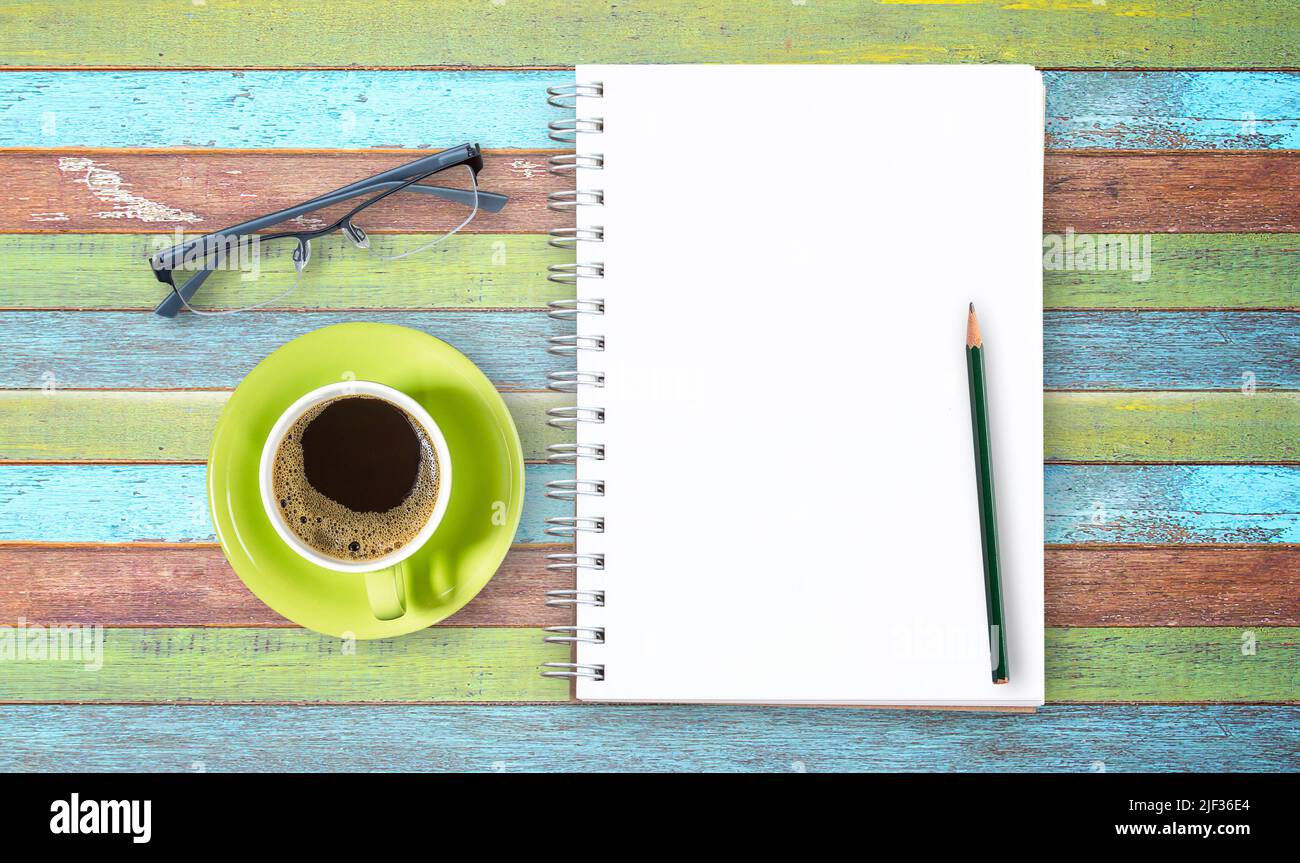 Blank notepad and pencil with cup of coffee on office wood table ...