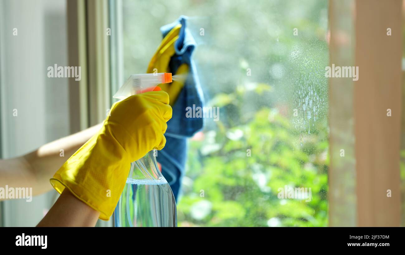 Hands in gloves wash window with rag Stock Photo - Alamy