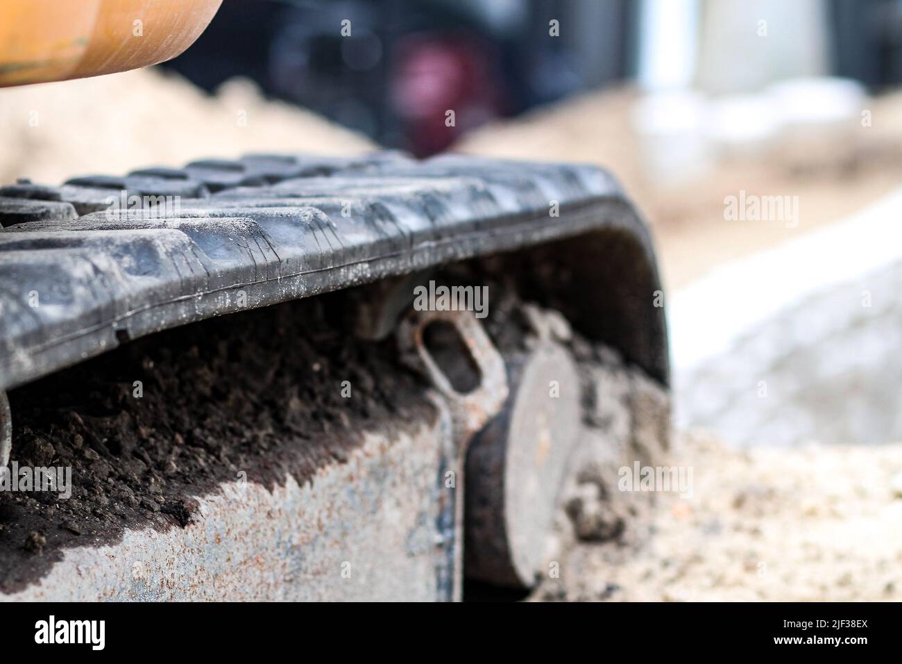 A close-up shot of an excavator track rubber tires during construction ...