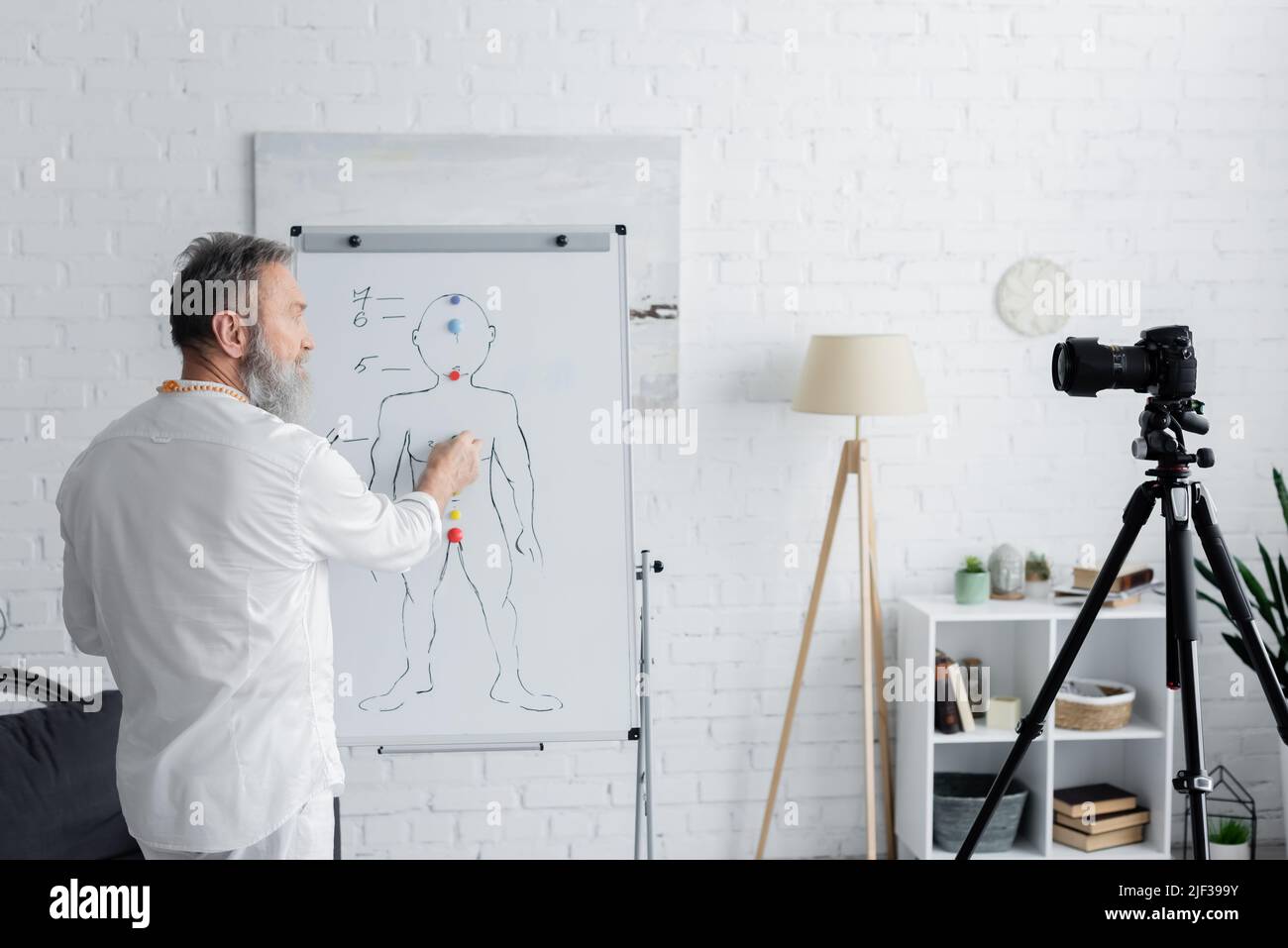 ayurveda guru near flip chart with human chakras system and digital ...