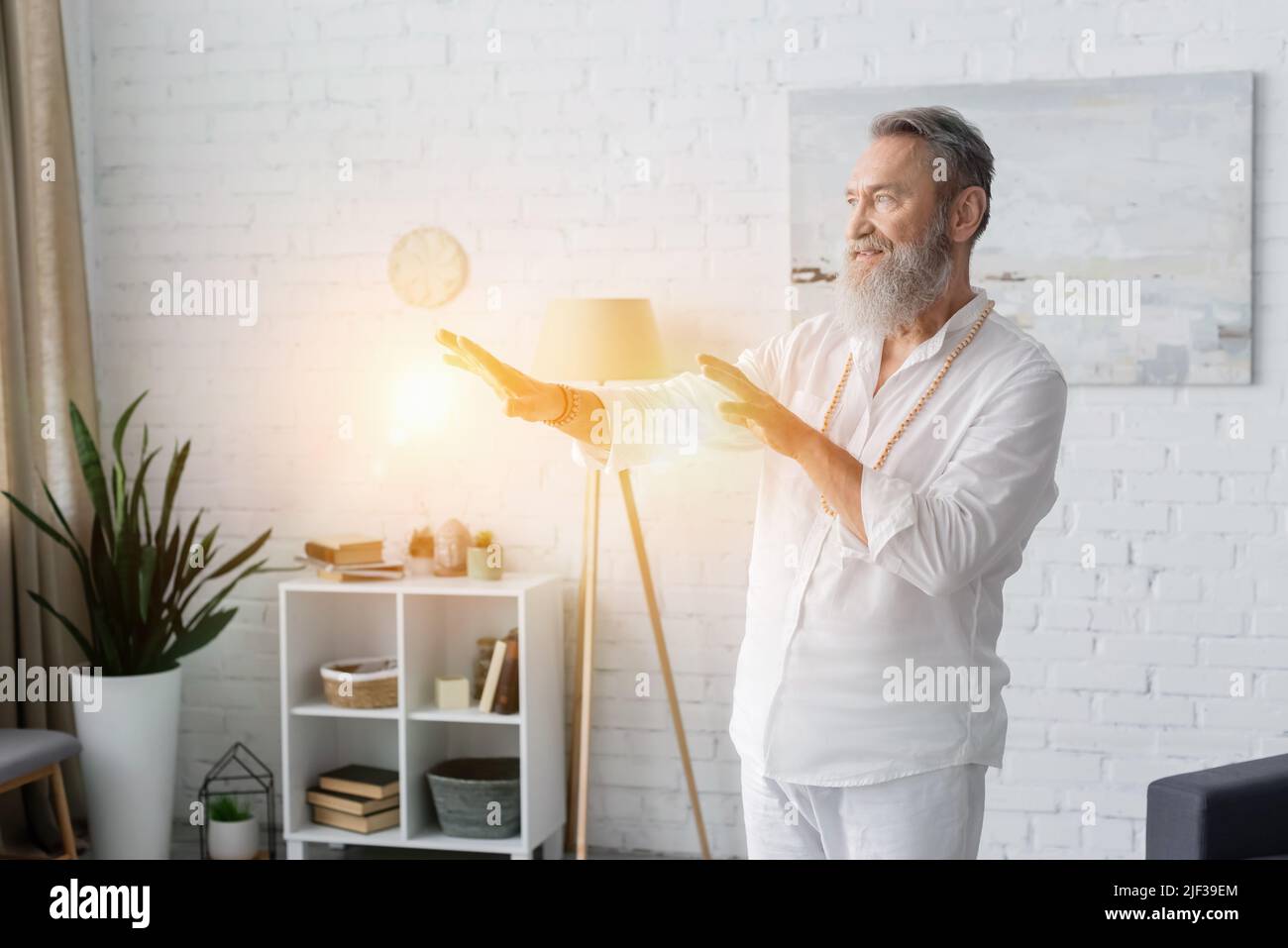 senior master guru meditating near light of aura at home Stock Photo ...