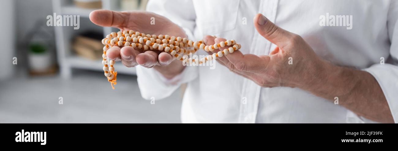 partial view of guru man holding mala beads, banner Stock Photo - Alamy