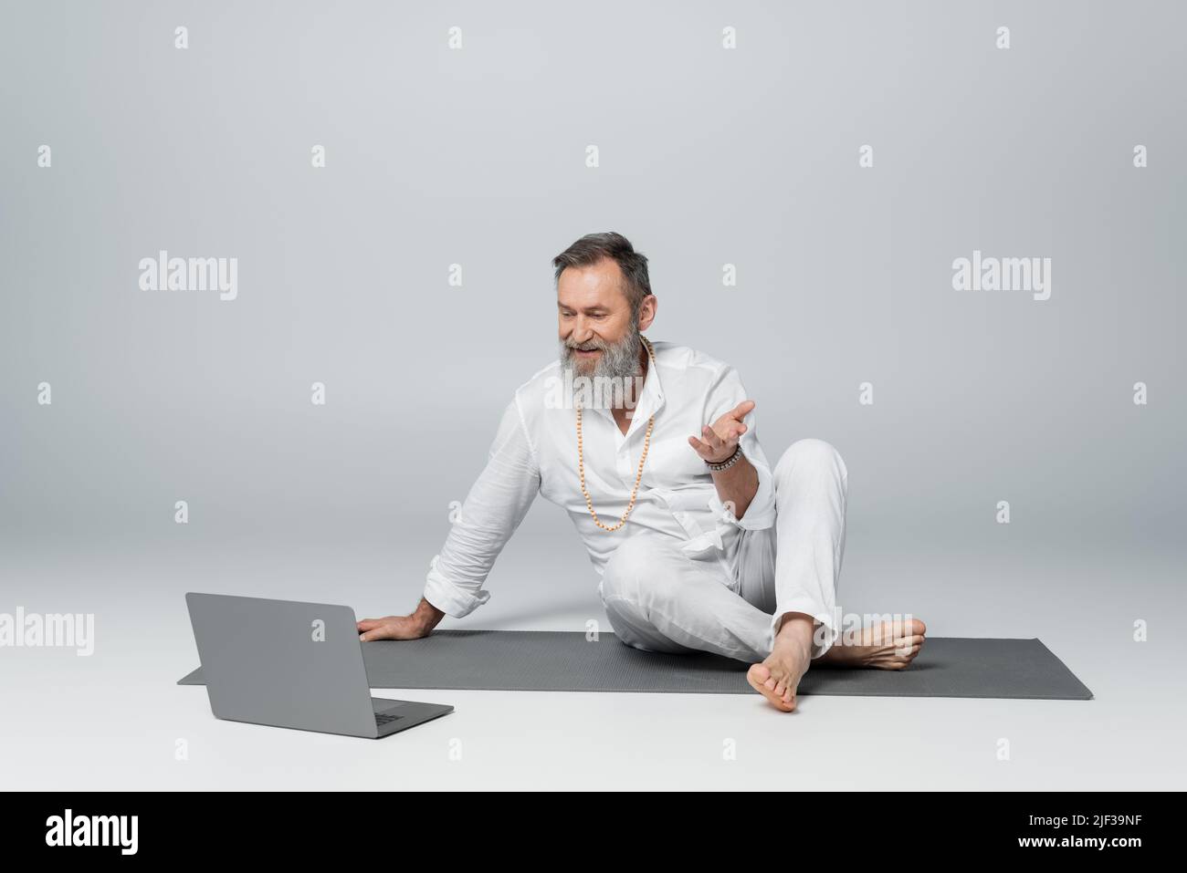 guru mentor sitting on yoga mat with crossed legs and talking near ...