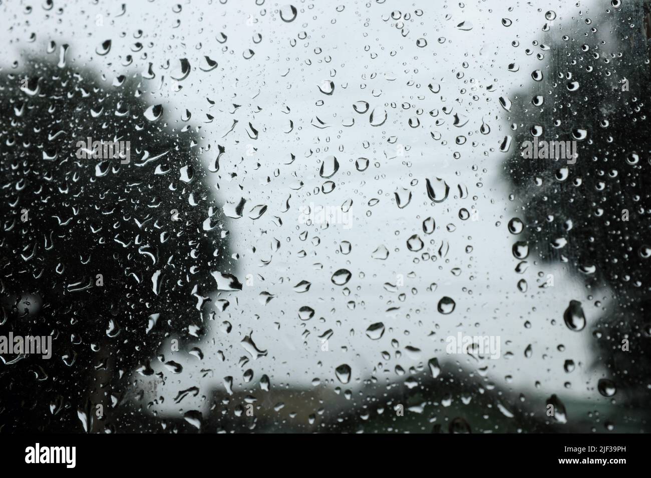 Selective focus of rain water droplets on house glass window. Rainy ...