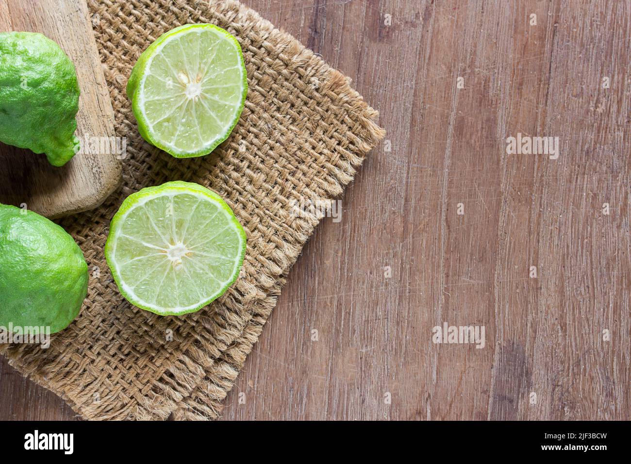 Close up fresh bergamot and bergamot slice on dark wood table ...