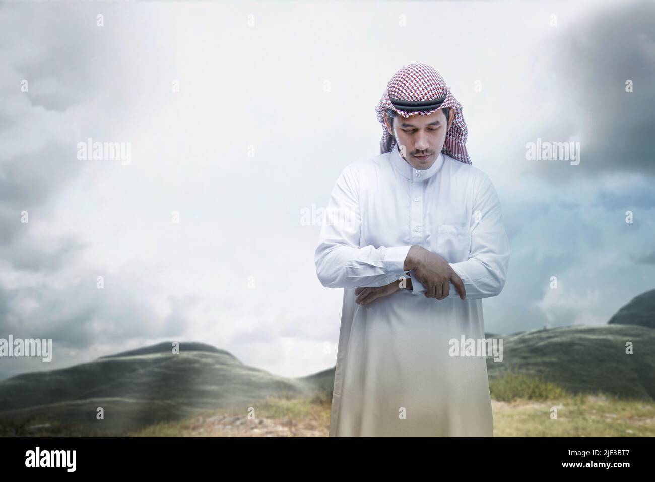 Muslim man with keffiyeh with agal in praying position (salat) with ...