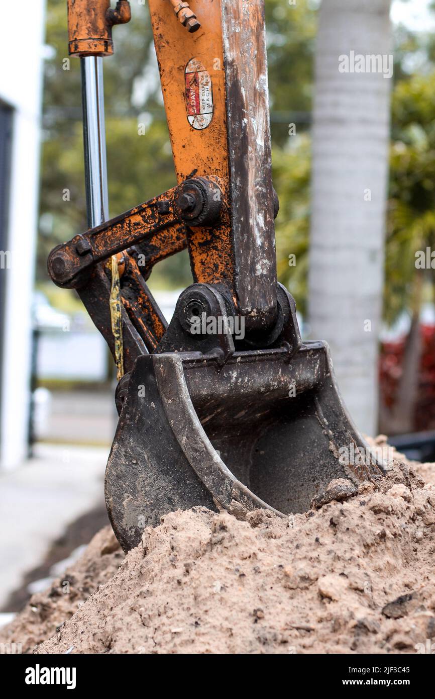 A vertical shot of a construction machine bucket digging in the soil ...
