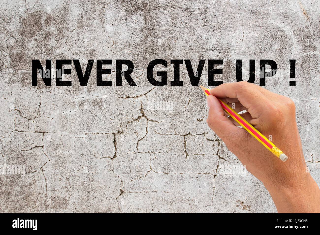 Hand with marker writing the text - Never give up! on grunge background ...