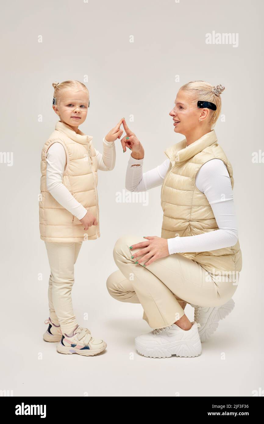 Woman with little girl in futuristic costume wearing smart led glasses ...