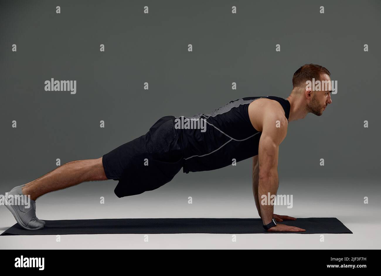 Handsome man doing plank exercise on floor indoors Stock Photo - Alamy