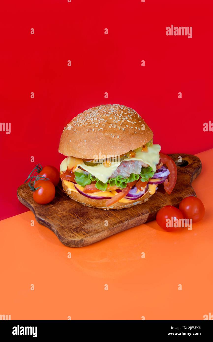 Delicious burger on the board with cutlet, tomatoes and cheese ...