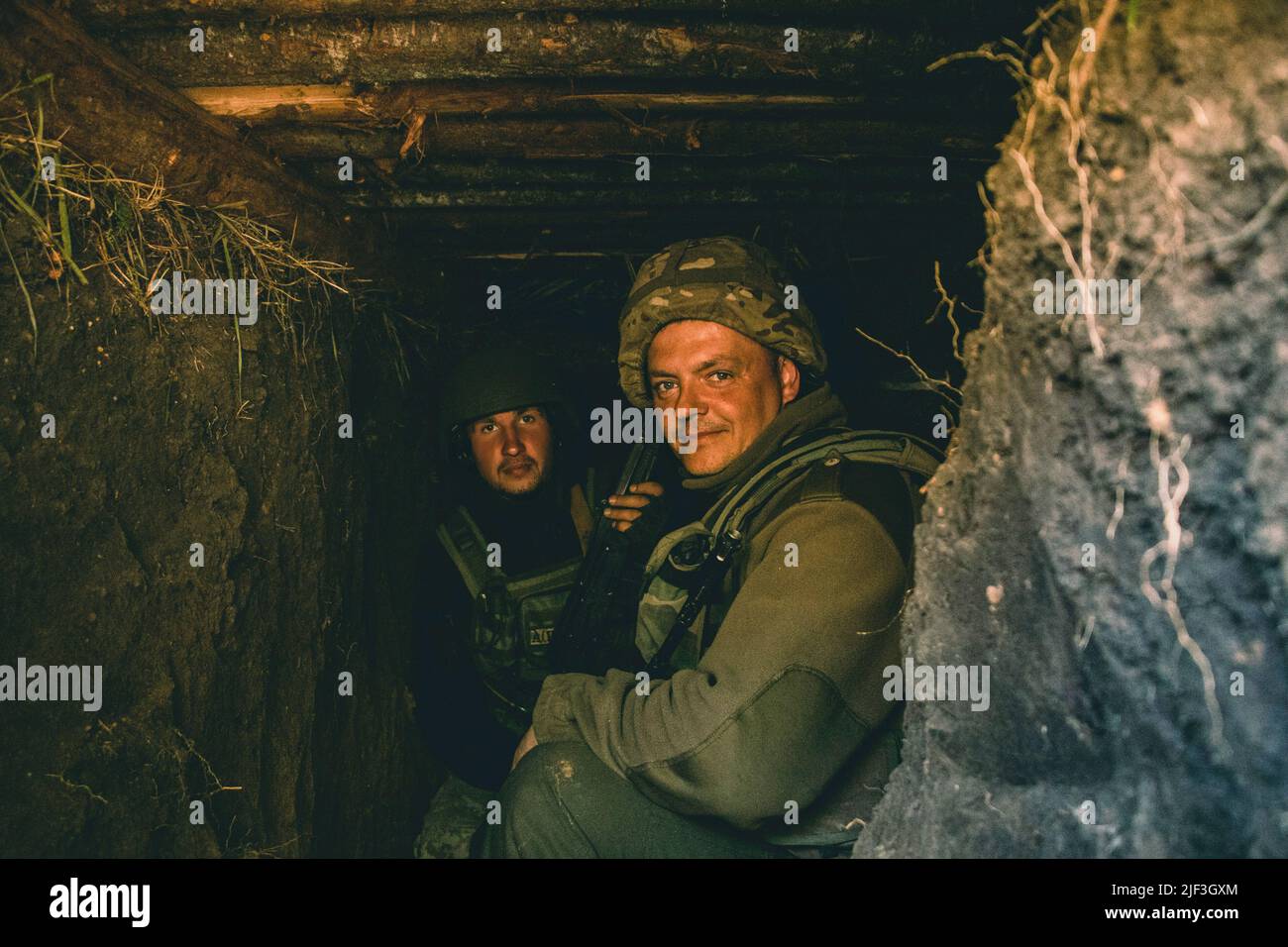 Two military soldiers hiding in a ditch. Ukrainian military soldiers ...