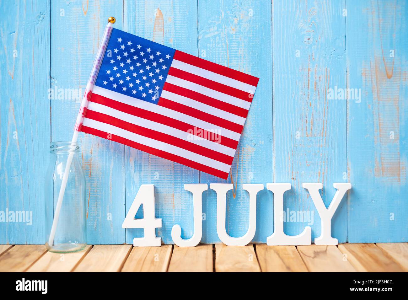Fourth of July text and United States of America flag on wooden table ...