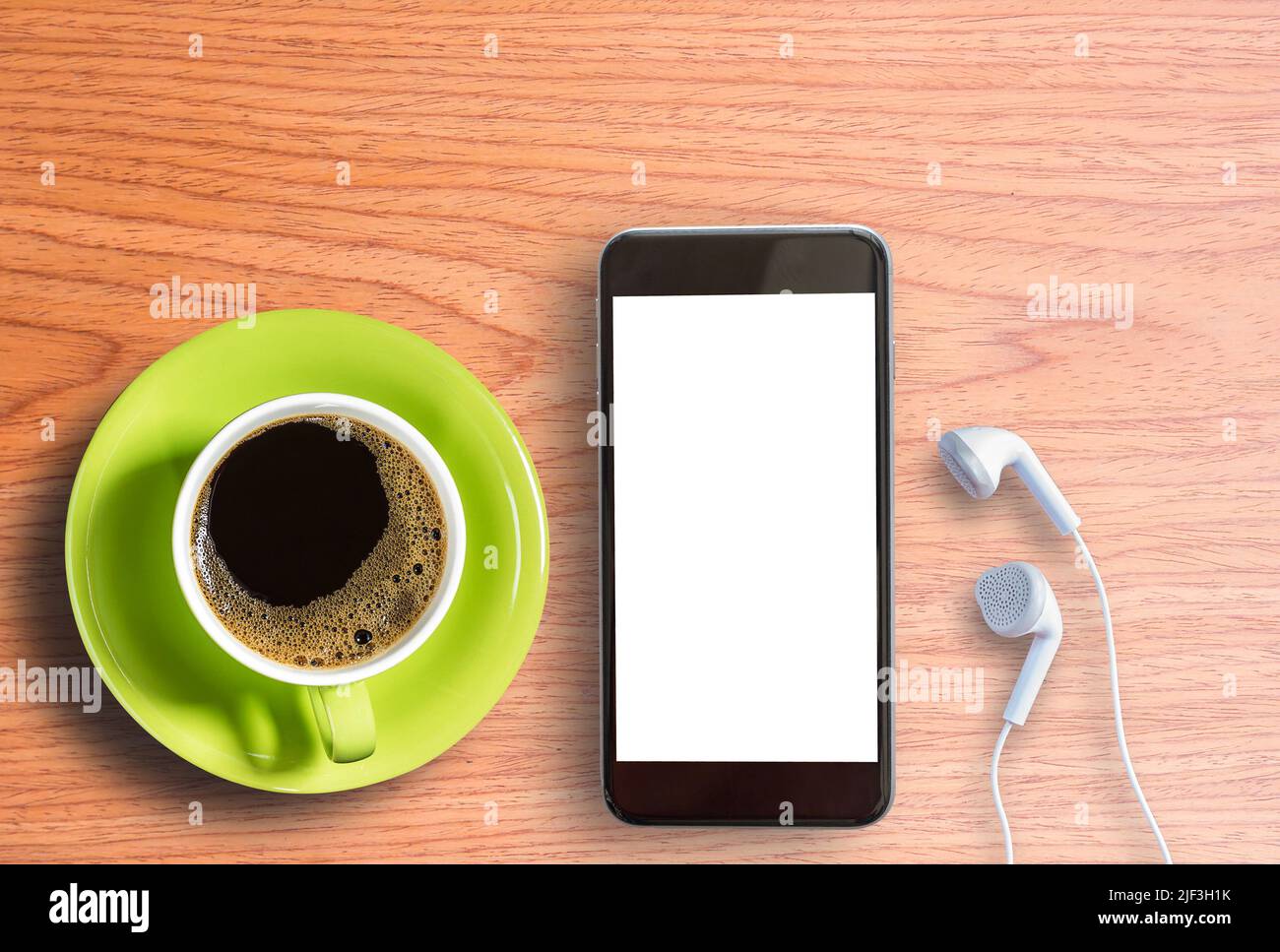 Cup of coffee with smart phone and earphone on wood table background ...