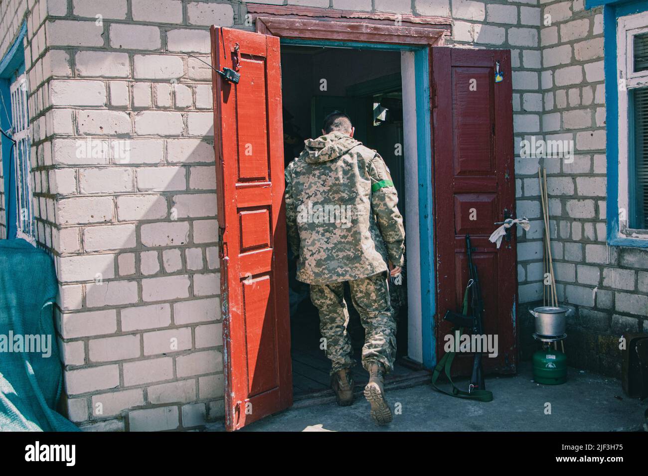 A soldier goes inside the house where the military from the frontline ...