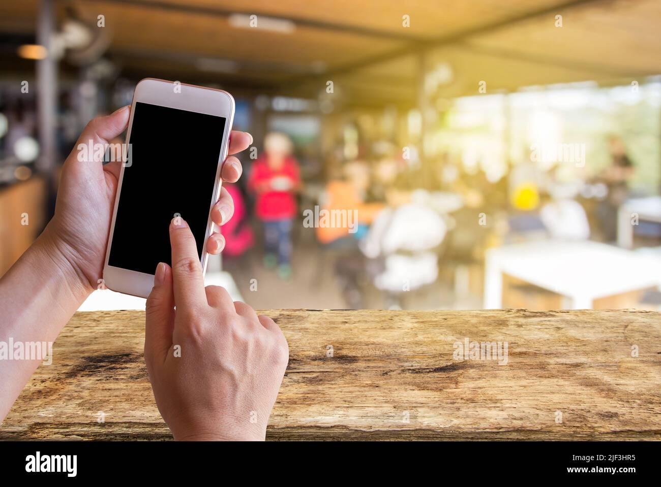 Women hand holding mobile smart phone with coffee shop blur background ...