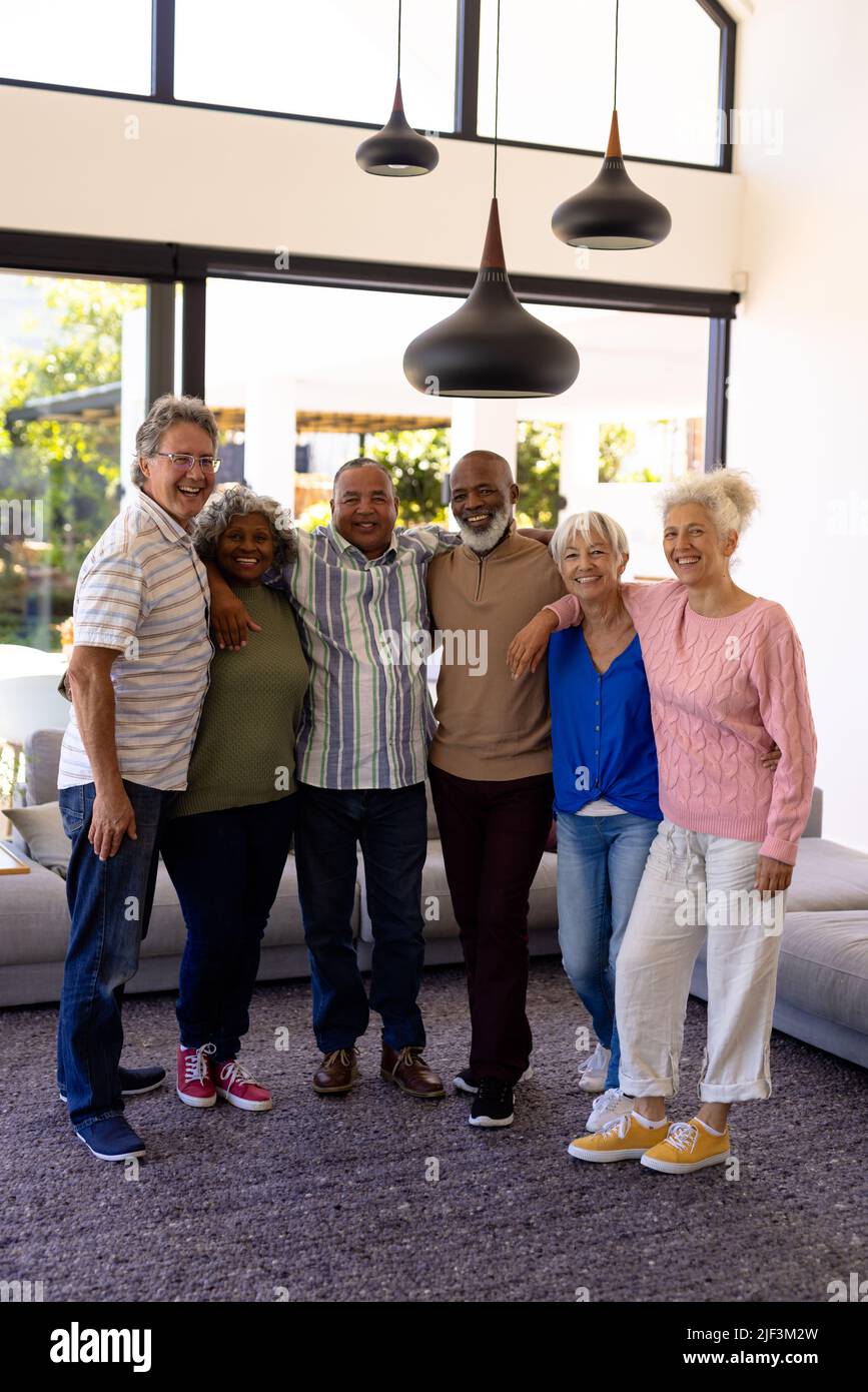 Portrait of multiracial senior friends with arms around standing ...
