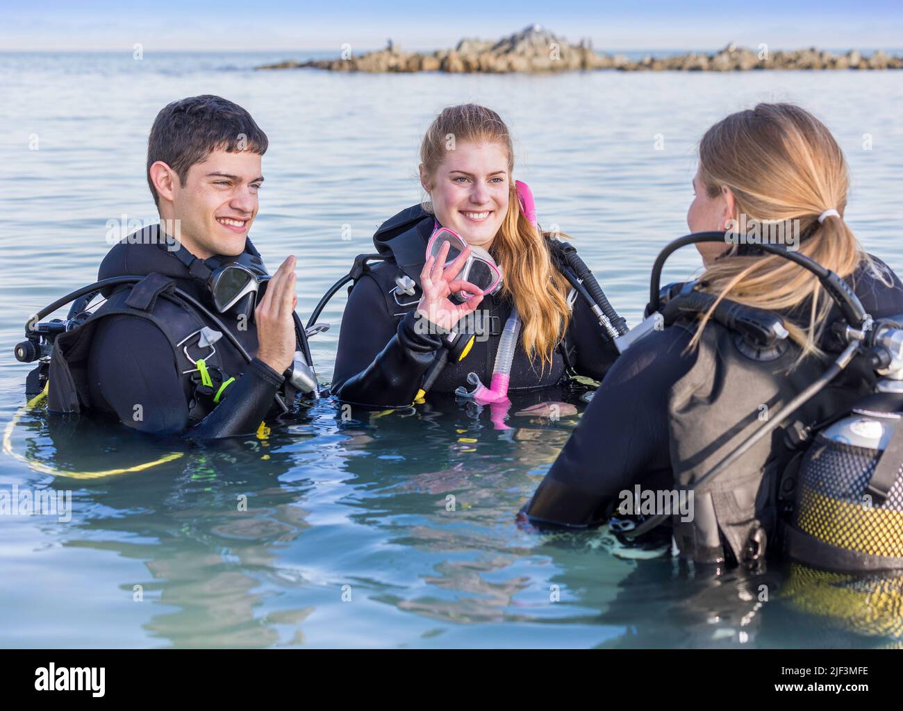 Happy scuba divers training in the sea looking at their instructor ...