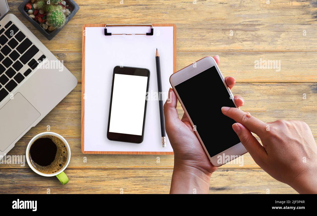 Hand holding smart phone and laptop computer,smart phone,clipboard ...