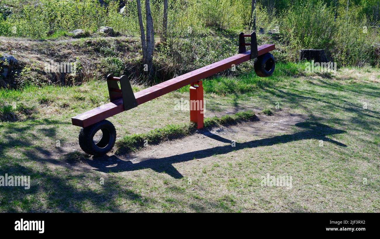 The empty red metal swing balancer in the playground Stock Photo - Alamy