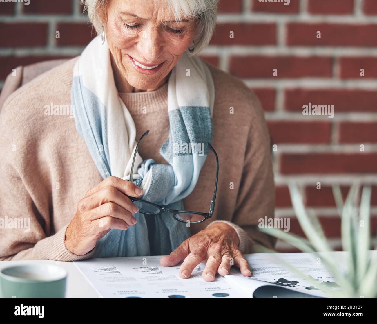 Senior woman reading retirement contracts. Mature woman sitting down ...