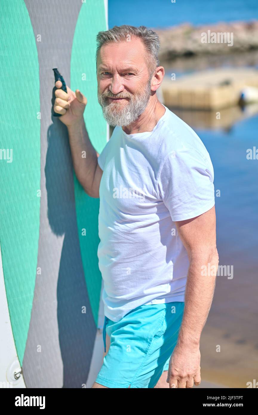 Confident man with surfboard looking at camera Stock Photo - Alamy