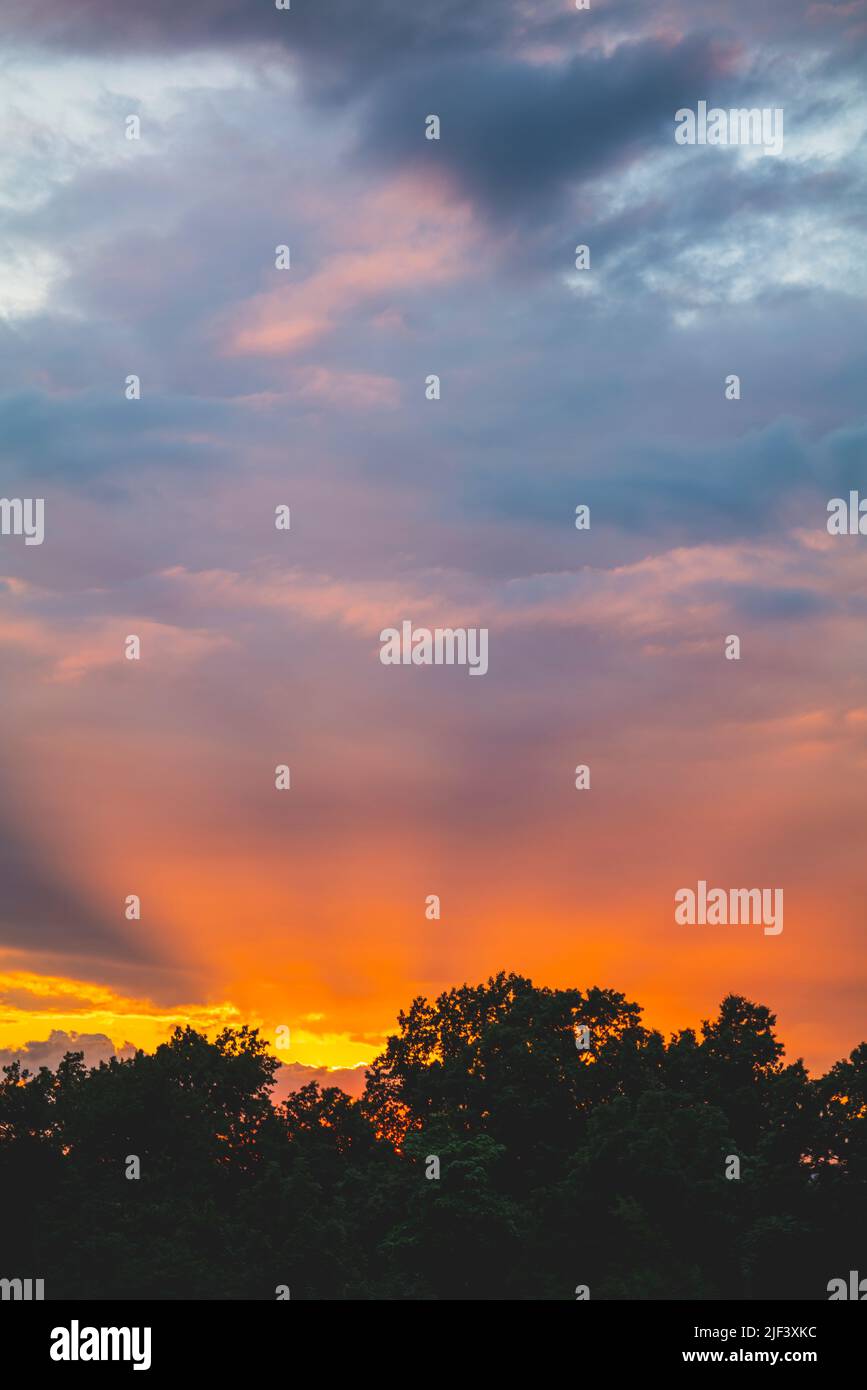 Dramatic sunbeams behind the Residential Building With Reflections in a ...