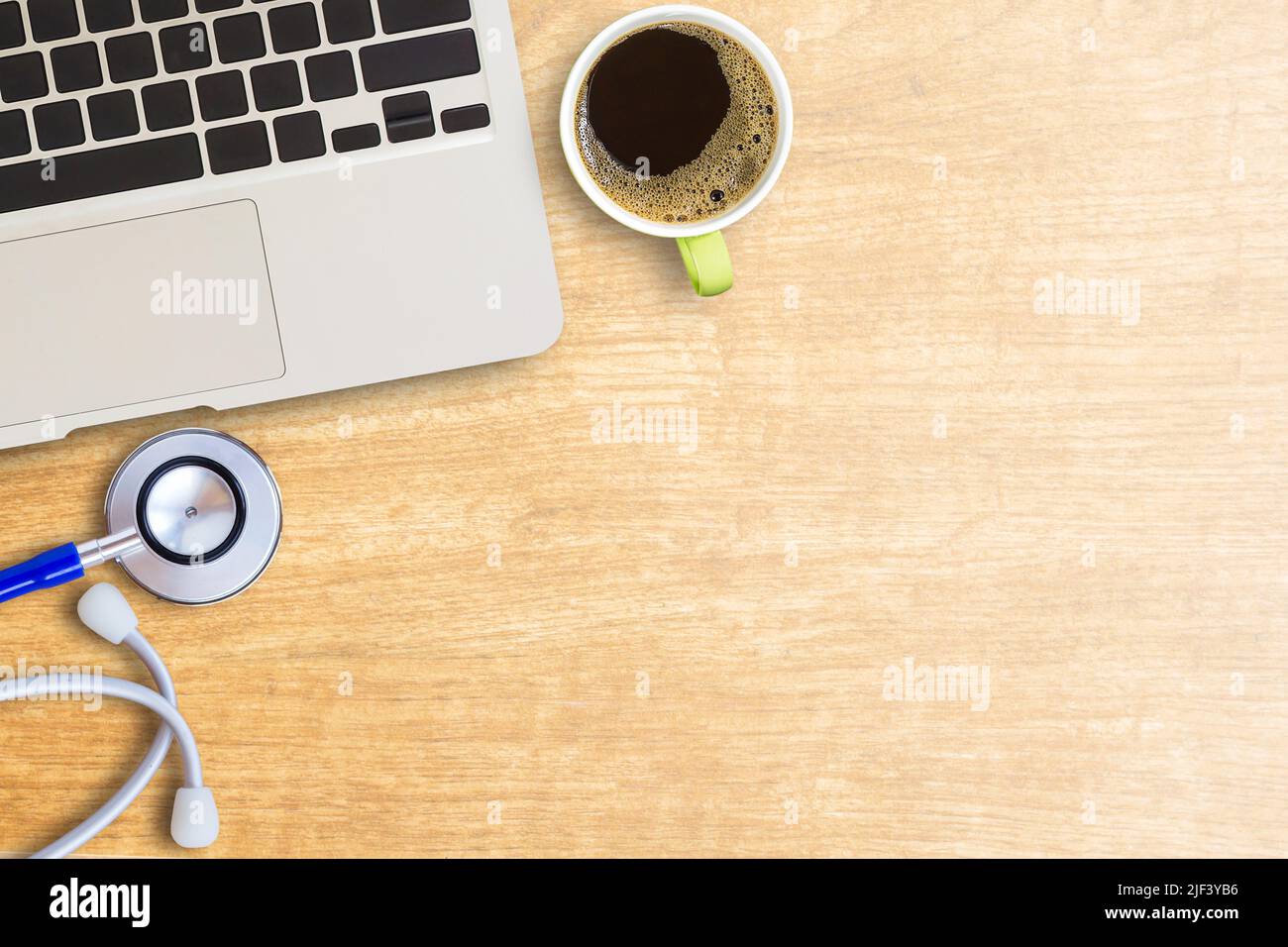 Laptop computer and stethoscope with cup of coffee on office desk ...