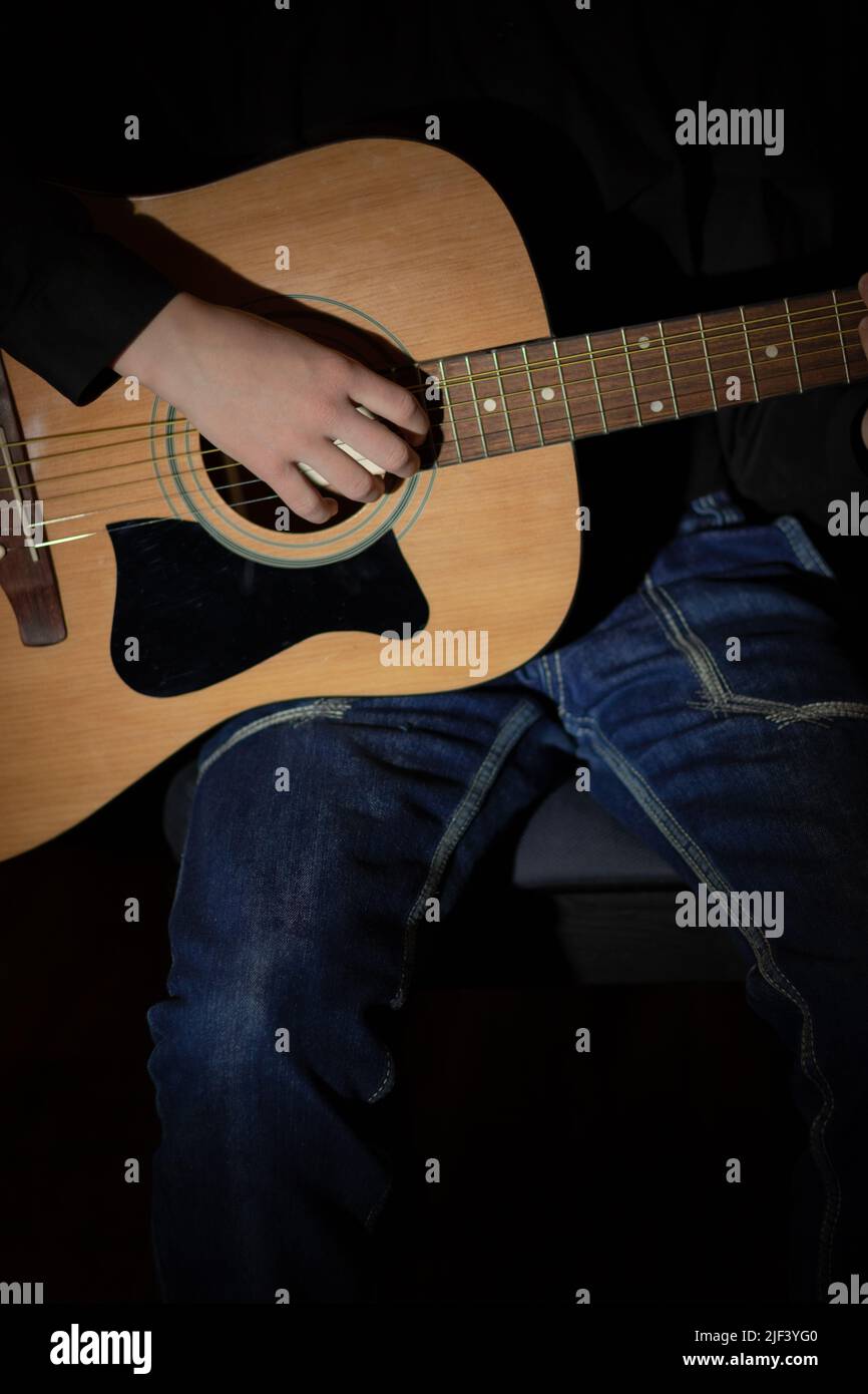 Hands of a musician playing an acoustic guitar with metal strings ...