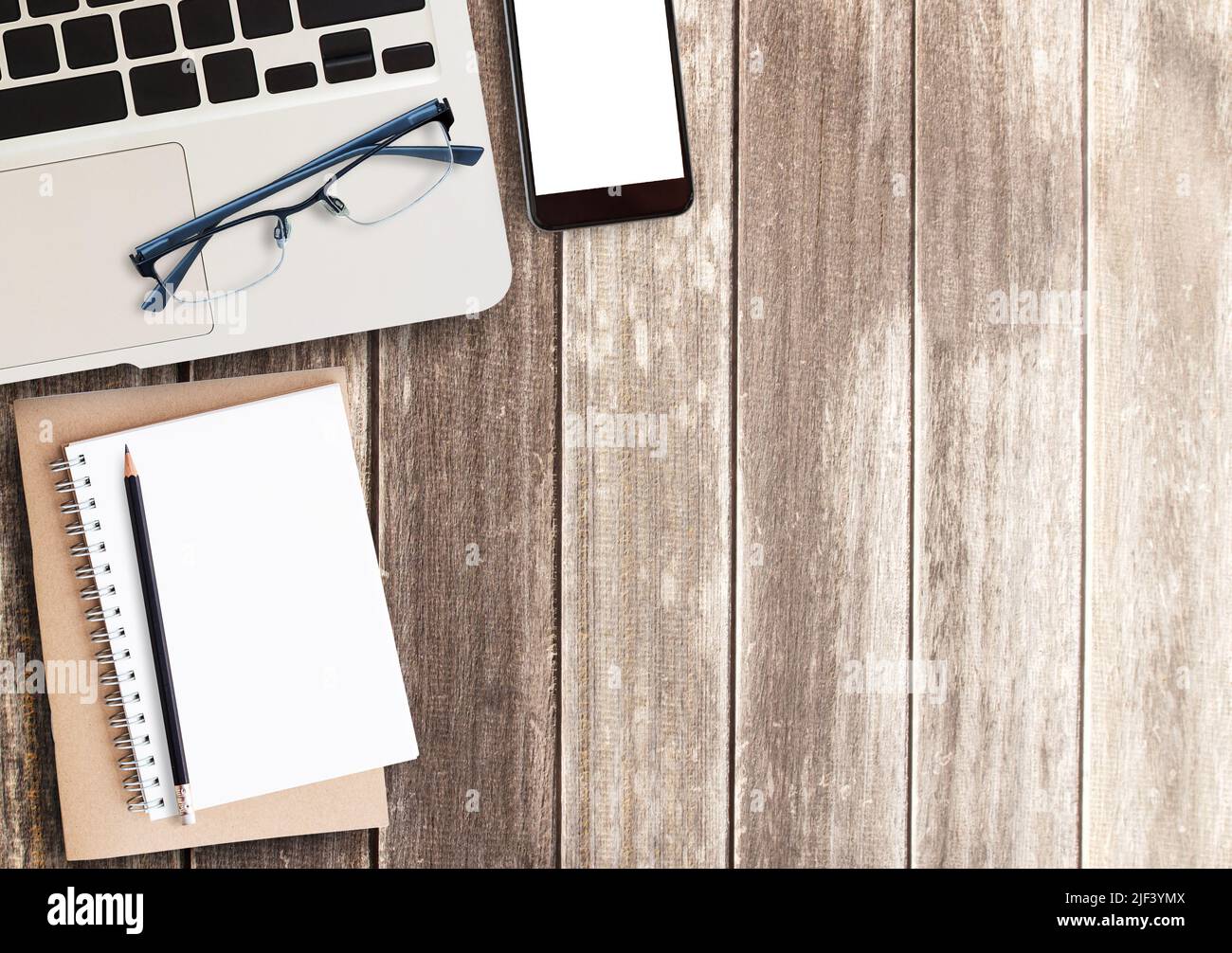 Office desk with laptop computer,glasses,notebook, and smart phone on ...