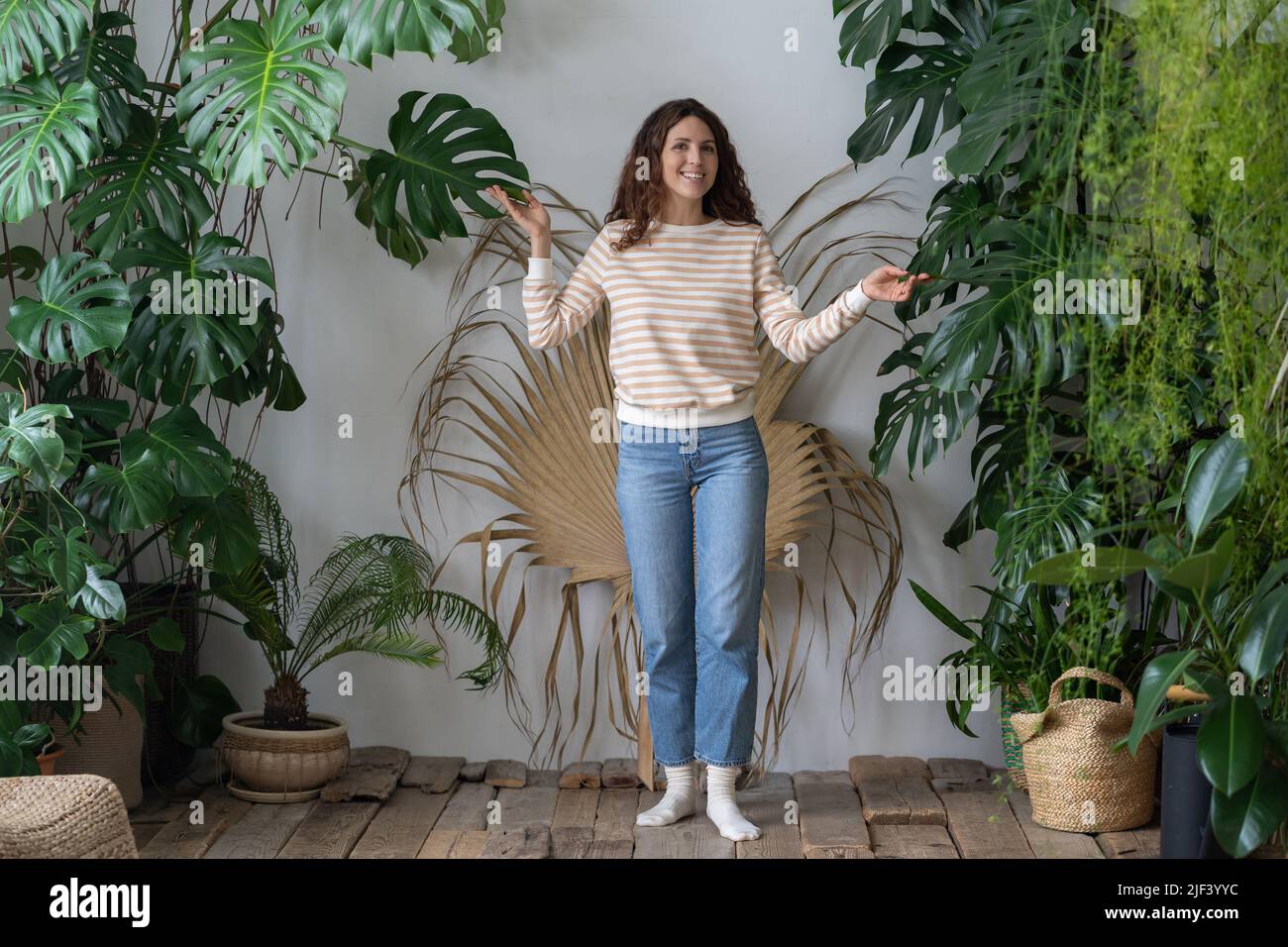 Happy young Italian woman among lush green tropical plants in tropical ...
